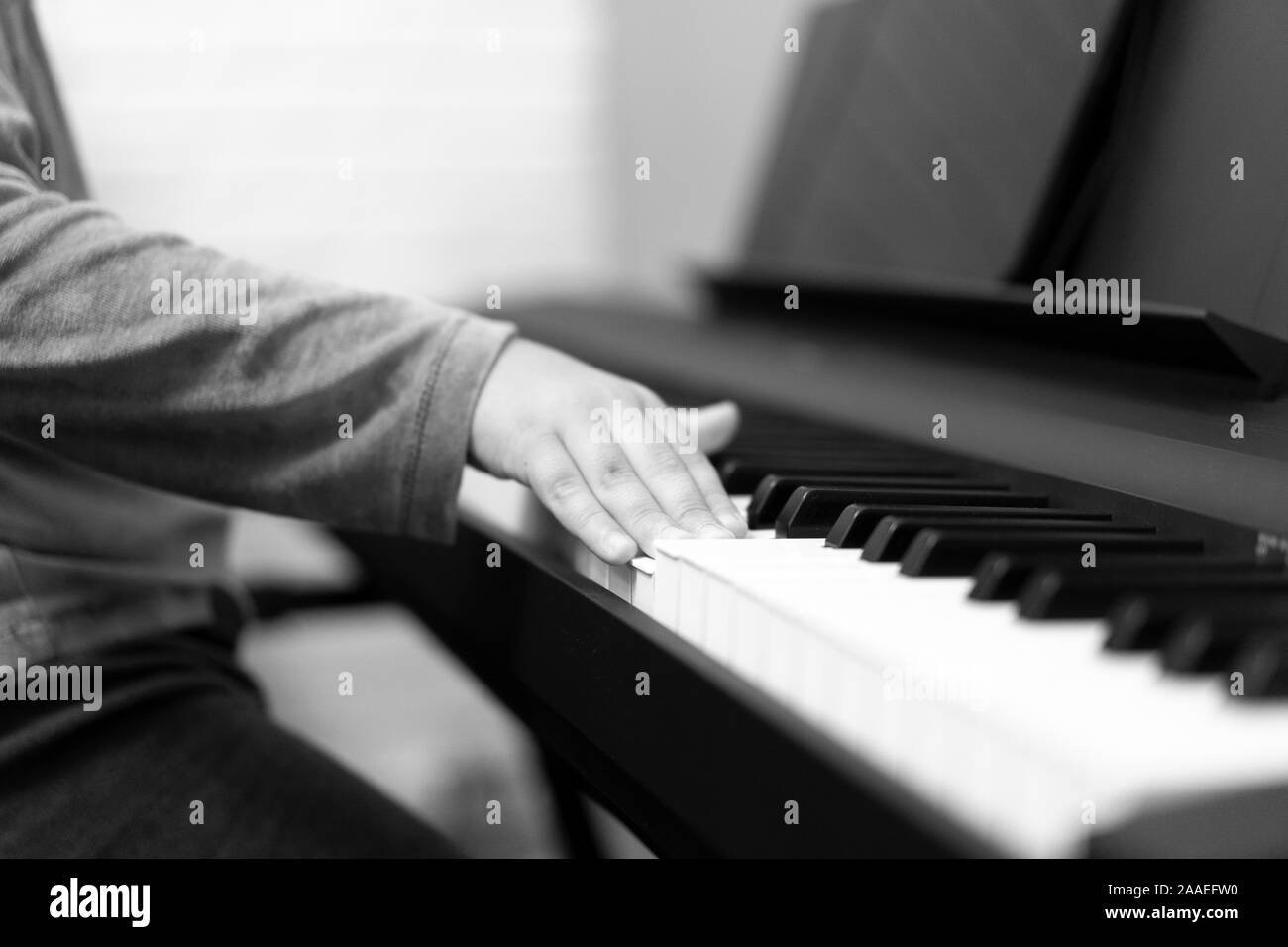 Hands of kid playing piano. Finger press on white key Stock Photo - Alamy