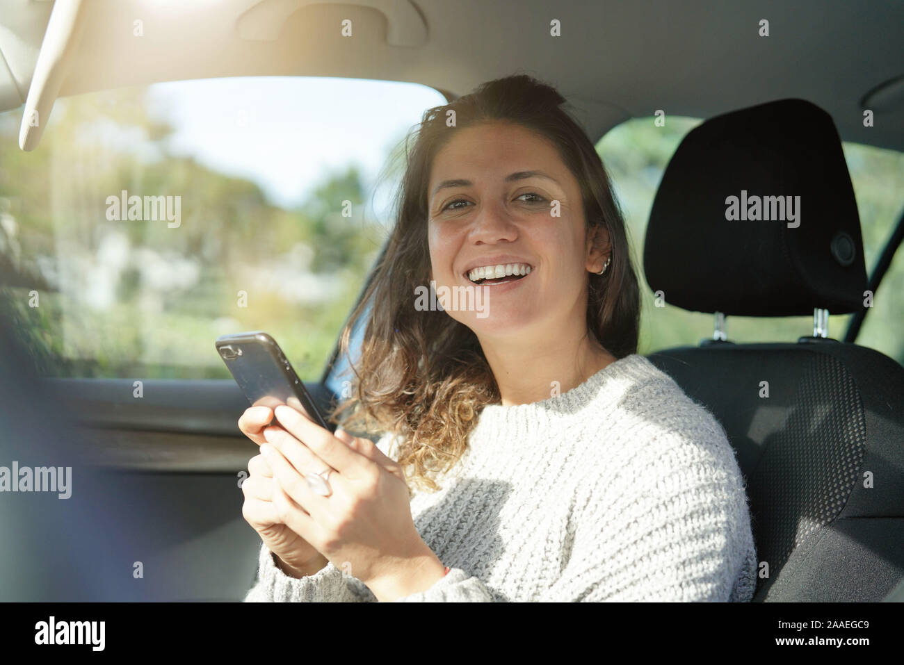 Attractive brunette texting in passenger seat of car Stock Photo - Alamy