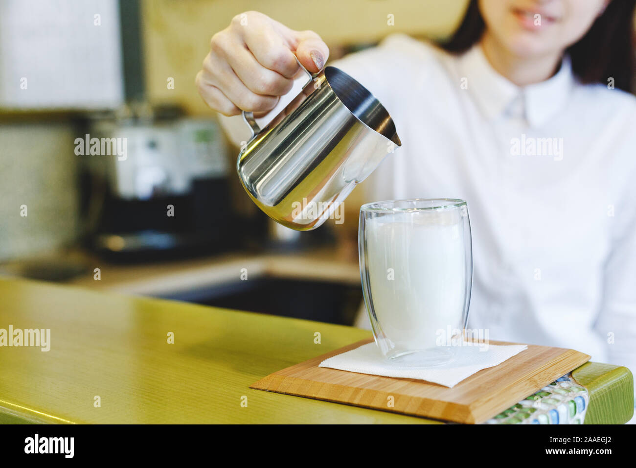 The process of making coffee latte. Young beautiful woman barista in ...