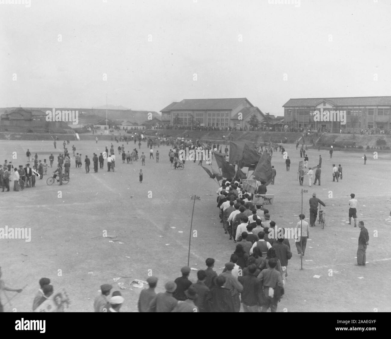 High-angle shot of a group of workers, from the back, holding flags and ...