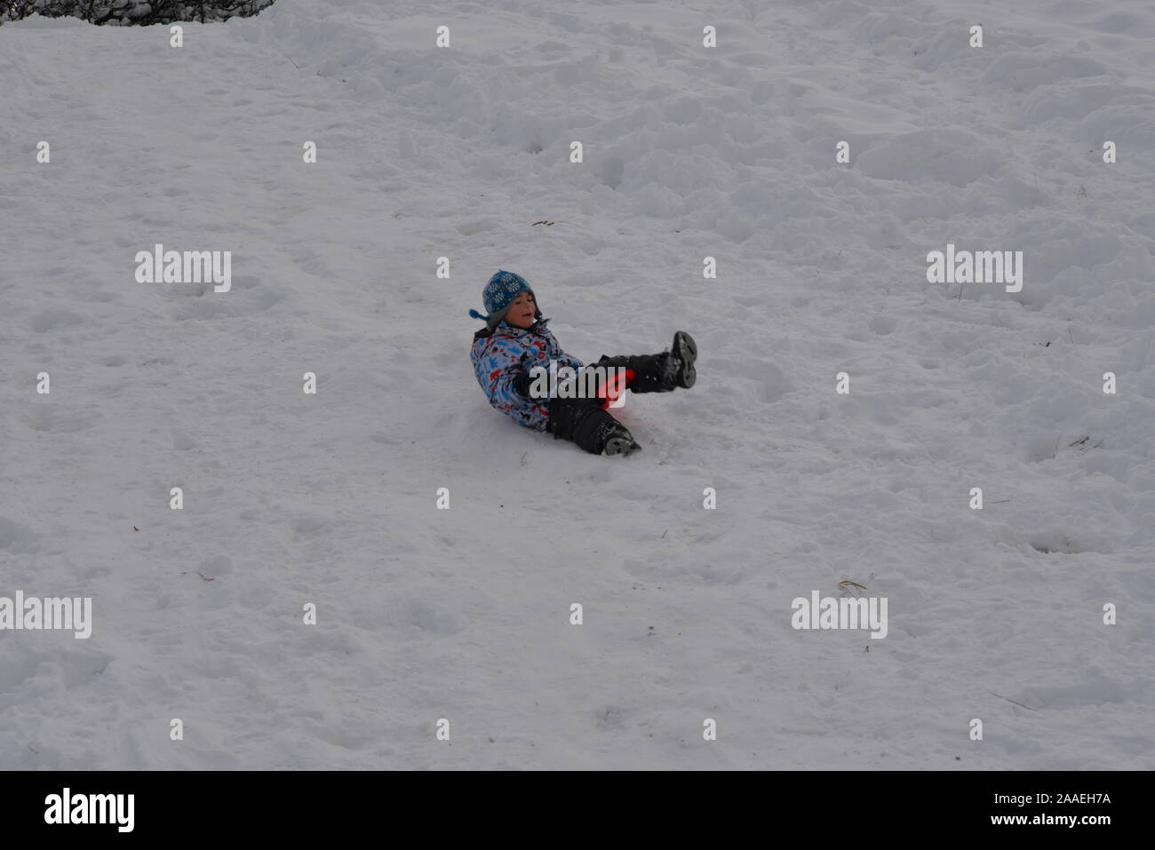 Fall of little boy in sledge Mercury Savoie Stock Photo - Alamy