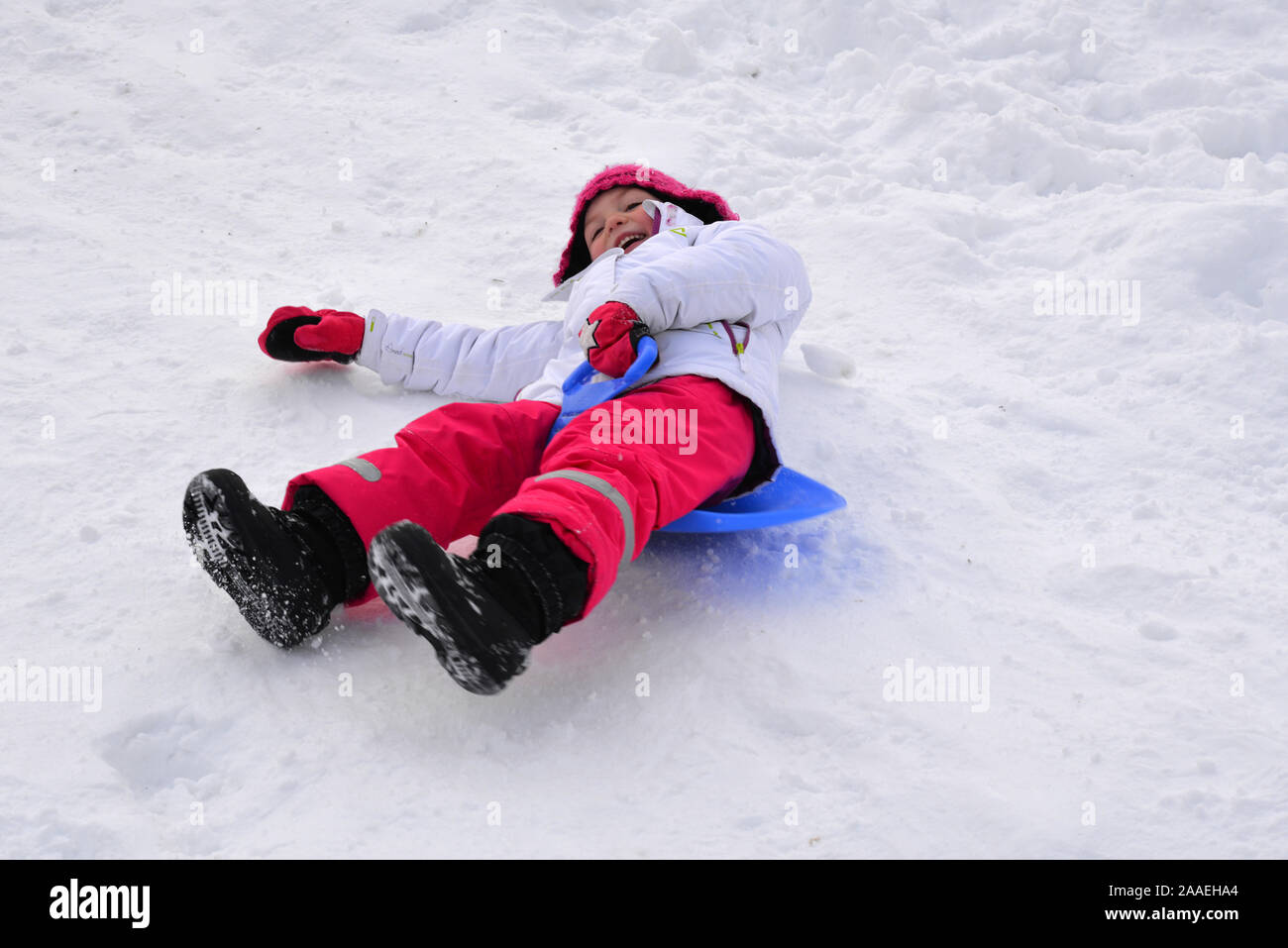 Fall of little girl in sledge Mercury Savoie Stock Photo - Alamy