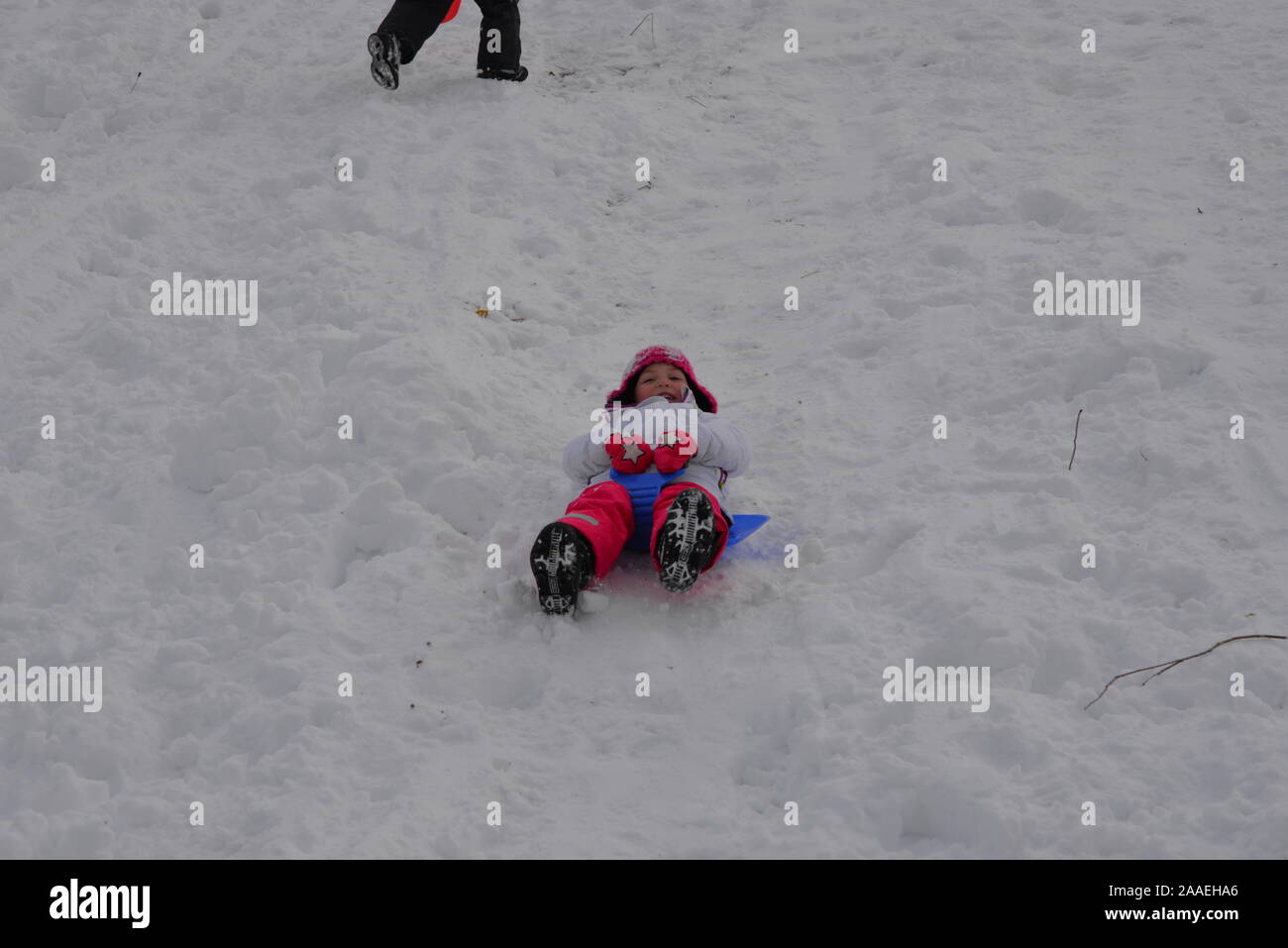 Fall of little girl in sledge Mercury Savoie Stock Photo - Alamy