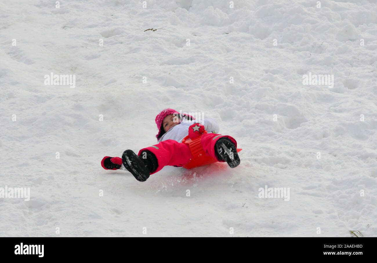 Fall of little girl in sledge Mercury Savoie Stock Photo - Alamy