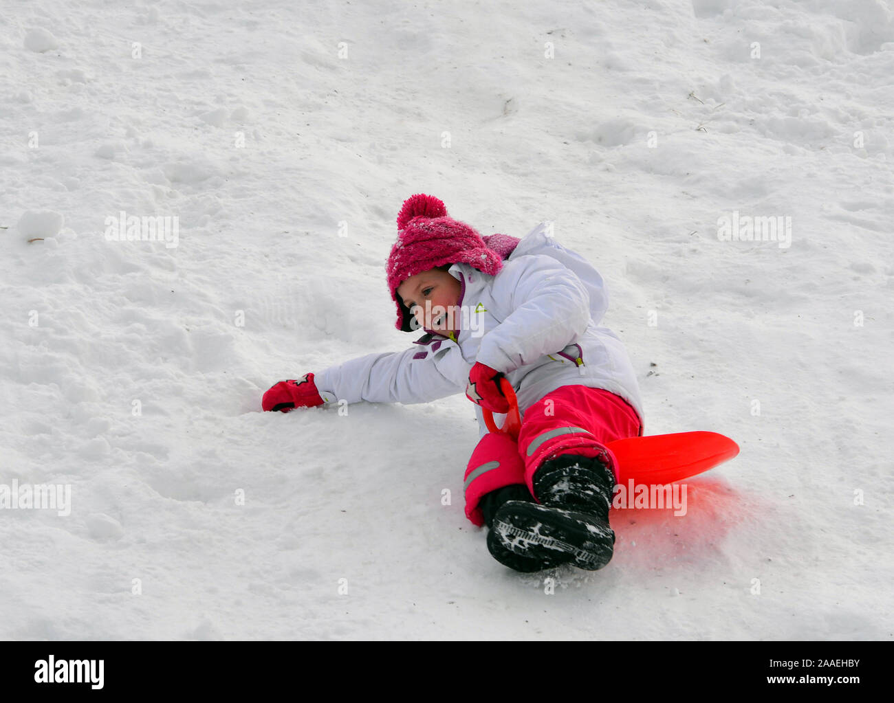 Fall of little girl in sledge Mercury Savoie Stock Photo - Alamy