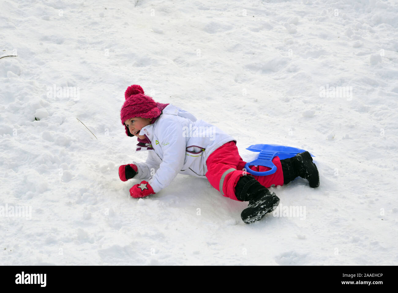 Fall of little girl in sledge Mercury Savoie Stock Photo - Alamy