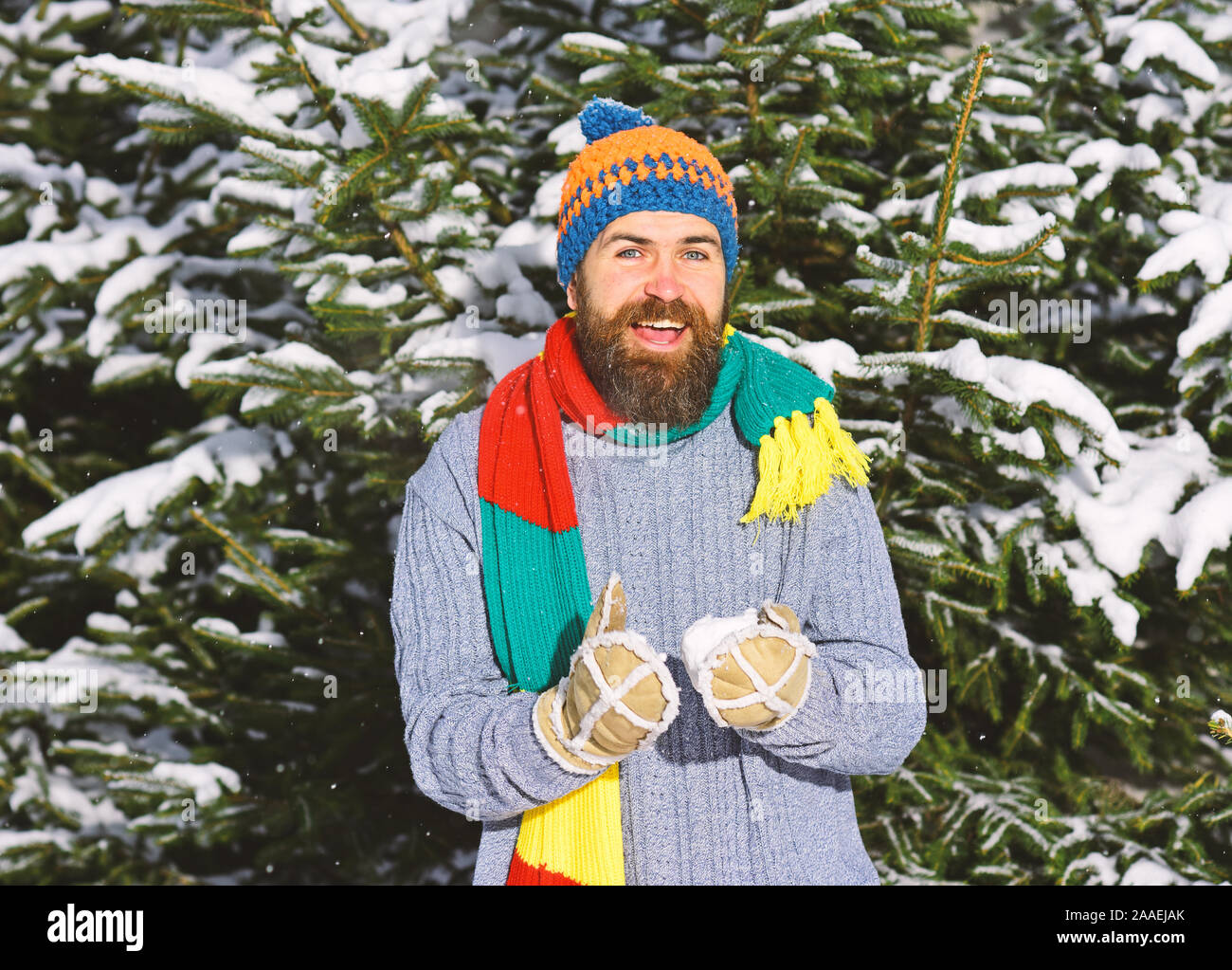 Macho with beard and mustache plays with snowball. Guy with happy face ...