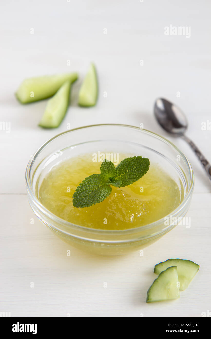 Cucumber vegetable jam in a glass bowl on a white background. Vertical ...