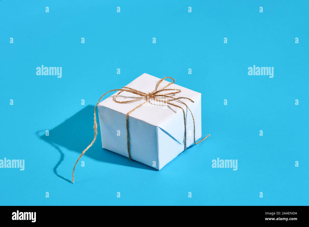 White gift box with thin tied rope with shadow on blue backgroun Stock ...