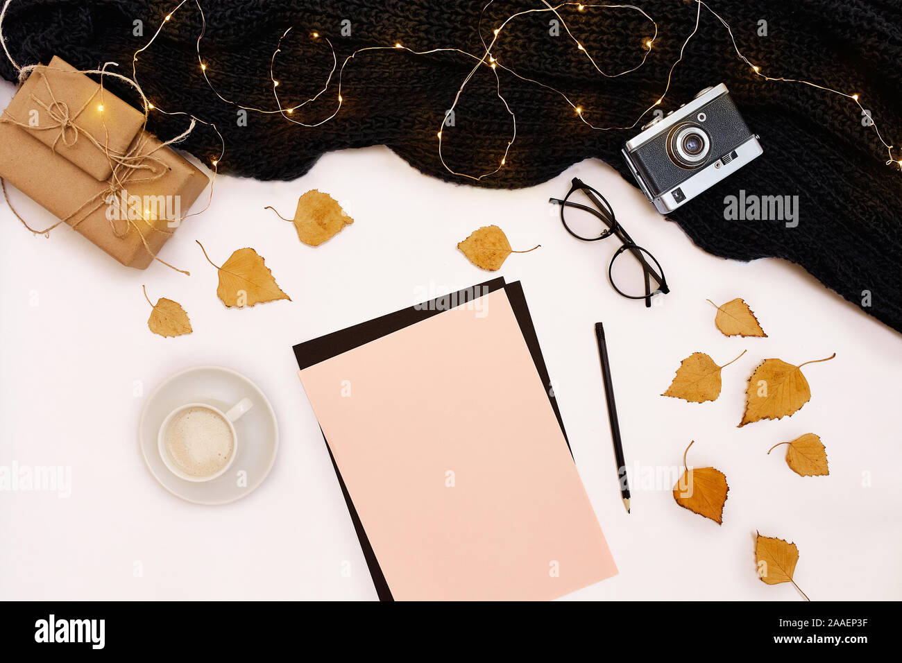 Romantic autumn mock up. Sheet of pink paper, yellow and orange leaves ...