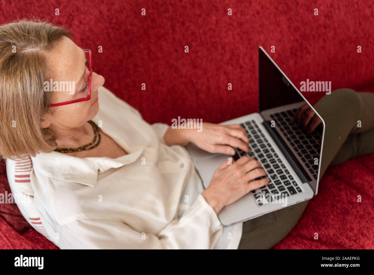 Elegant mature woman using computer at home Stock Photo - Alamy