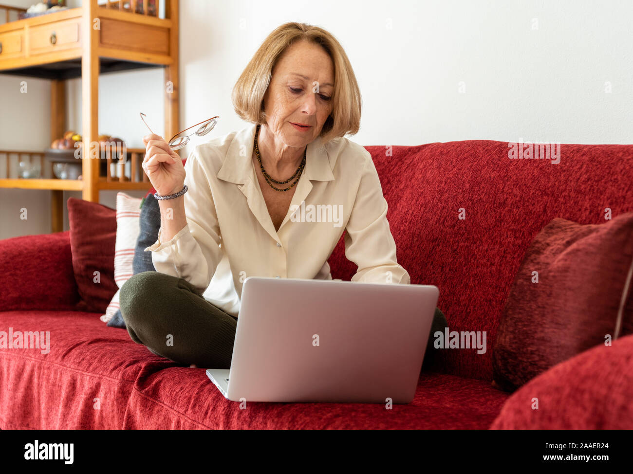 Elegant mature woman using computer at home Stock Photo - Alamy