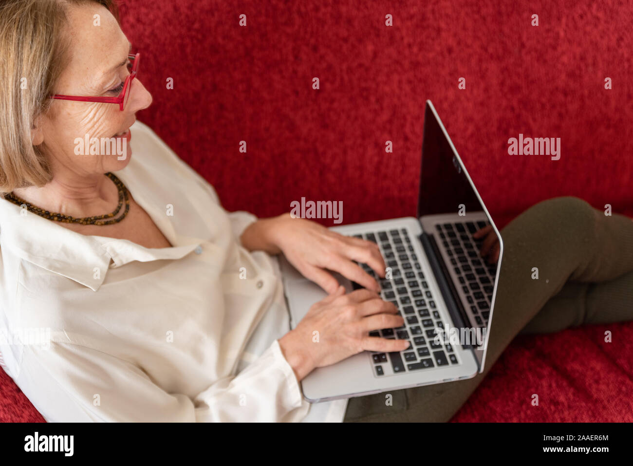 Elegant mature woman using computer at home Stock Photo - Alamy