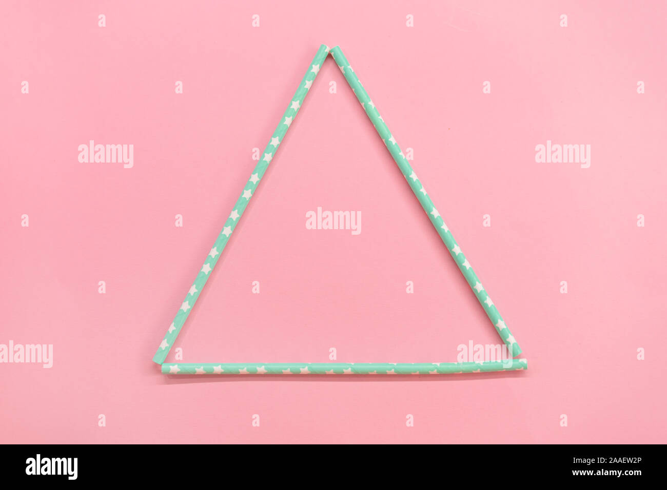 triangular frame with Colorful Paper coctail tubes on the pink ...