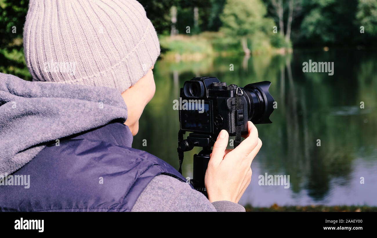 Girl photographer. The tripod with the camera Stock Photo - Alamy