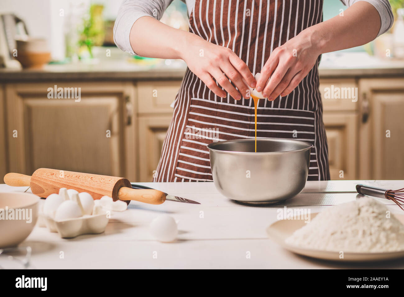 Female hands breaking egg bowl hi-res stock photography and images - Alamy