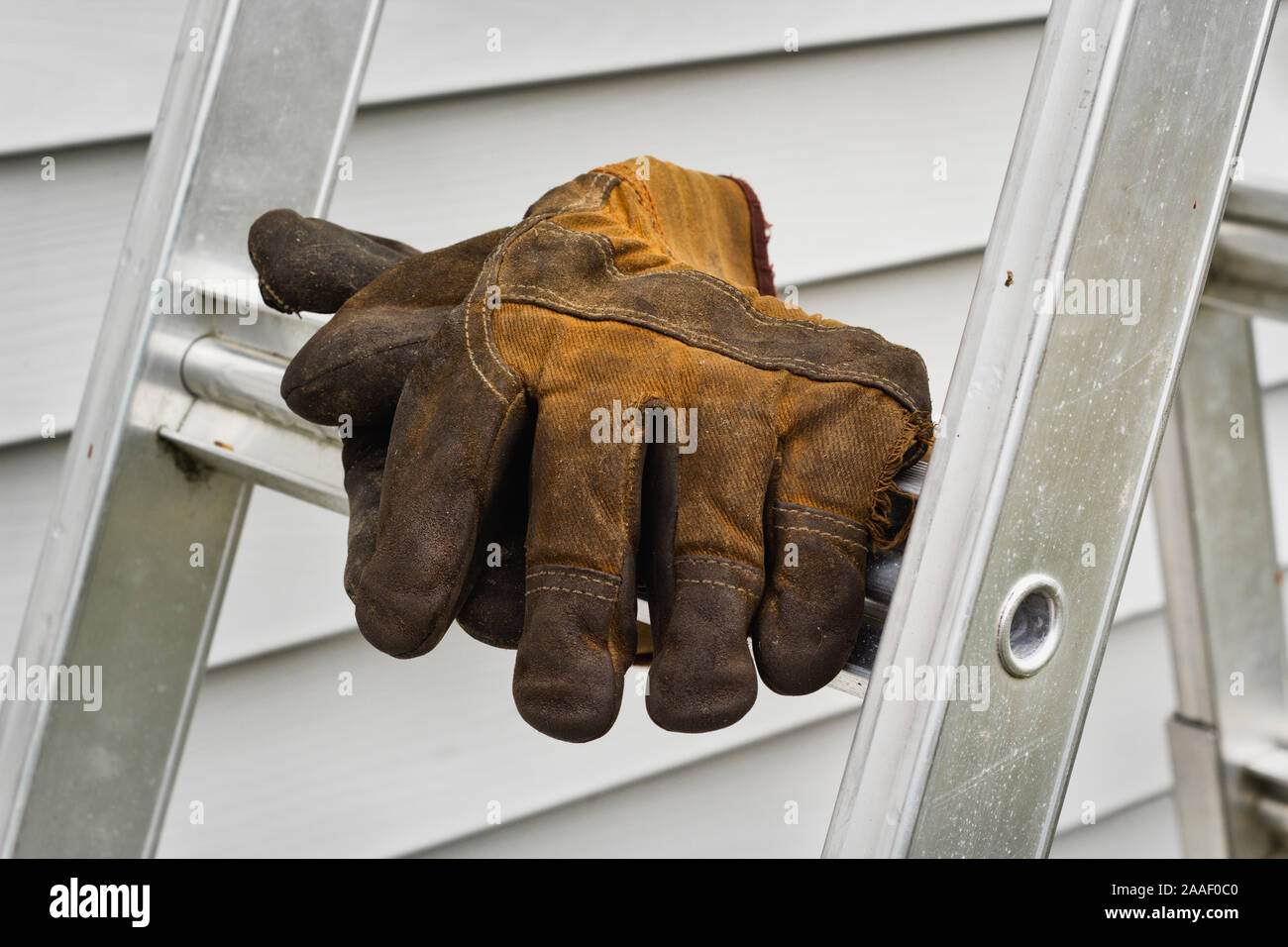 Work gloves and ladder detail with exterior siding background Stock ...