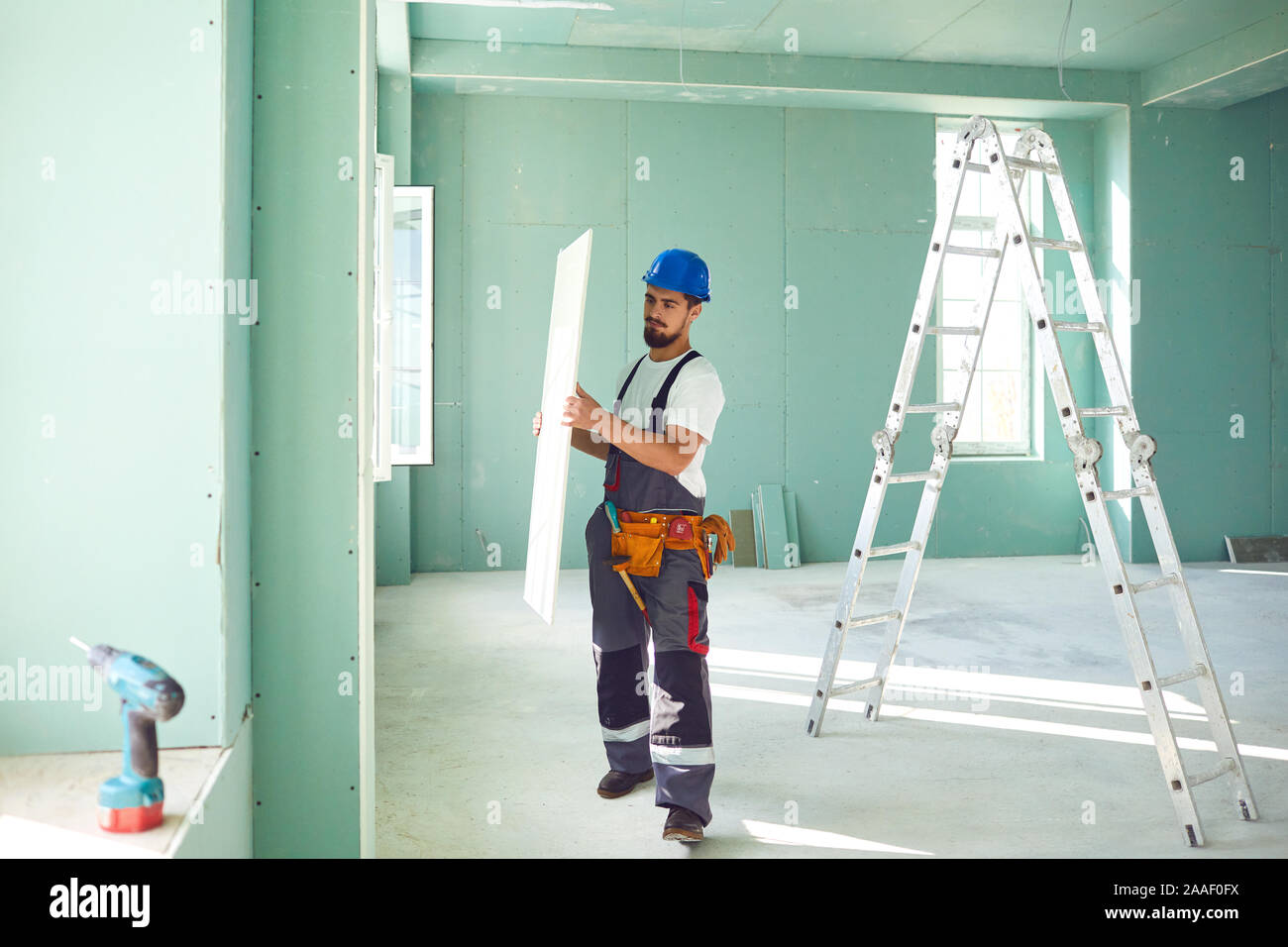 Worker builder installs plasterboard drywall at a construction Stock ...