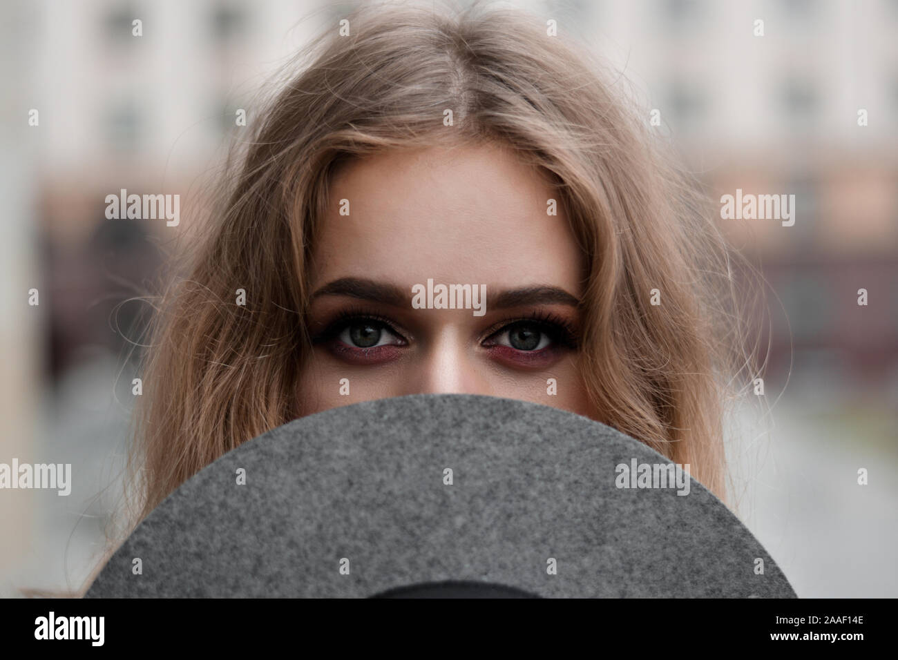 Shy girl with beautiful eyes on street background. Horizontal close up ...