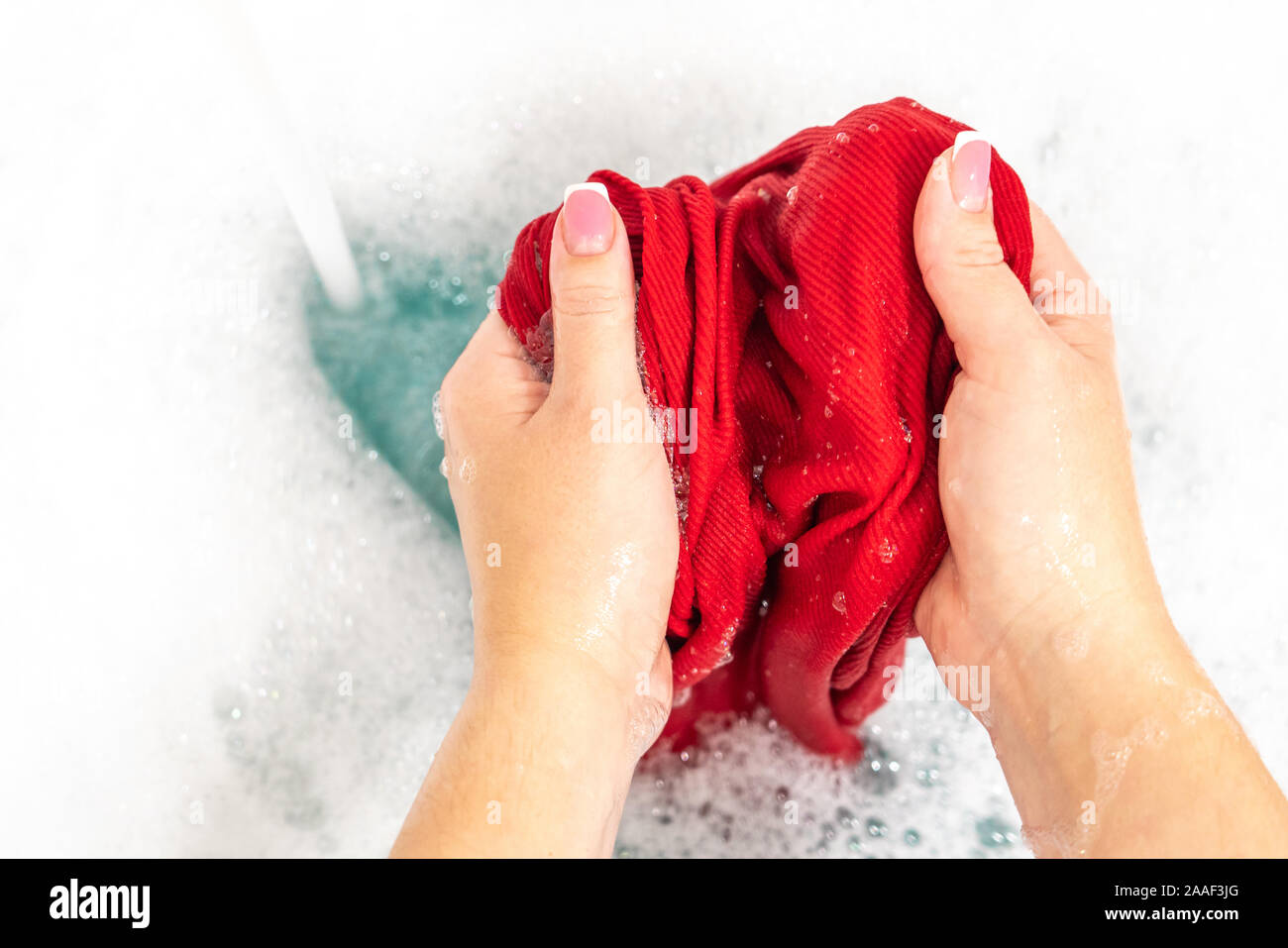 Female hands washing color clothes in basin Stock Photo - Alamy
