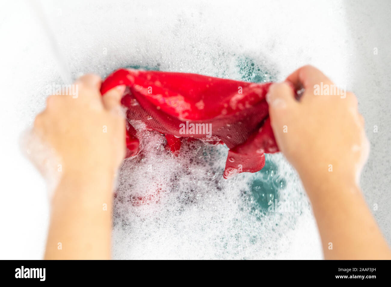Female hands washing color clothes in basin Stock Photo - Alamy
