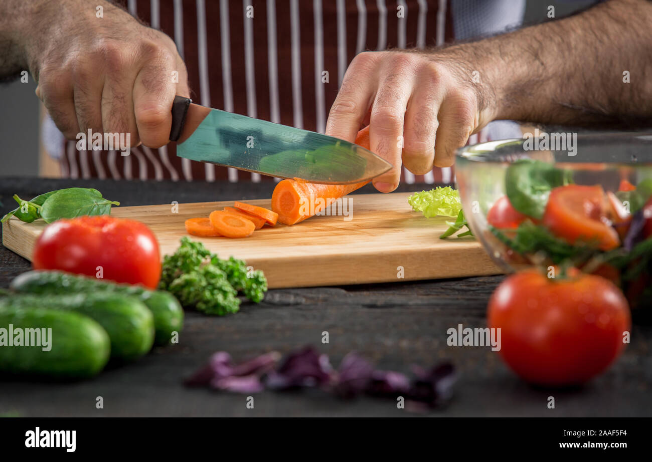 Male hands cutting vegetables for salad Stock Photo - Alamy