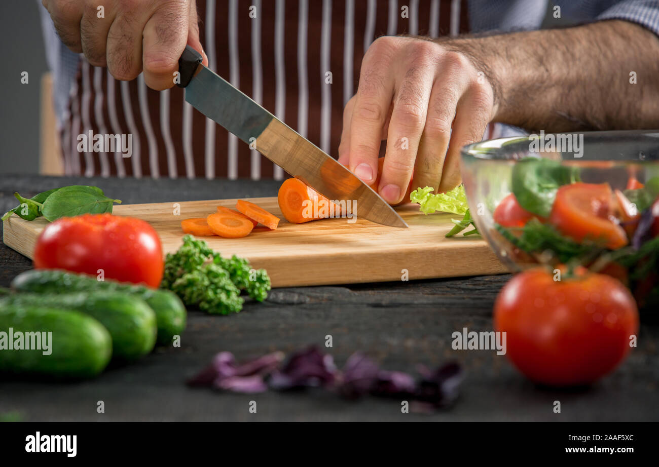 Male hands cutting vegetables for salad Stock Photo - Alamy