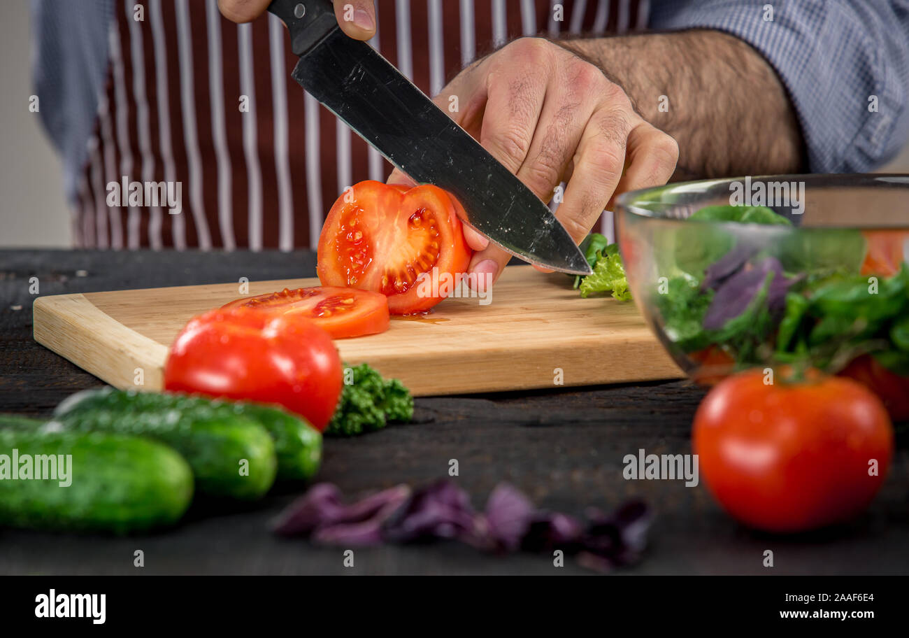 Male hands cutting vegetables for salad Stock Photo - Alamy
