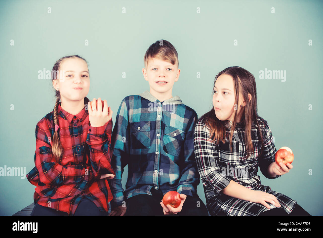 School snack concept. Group cheerful teenagers having fun and eating ...