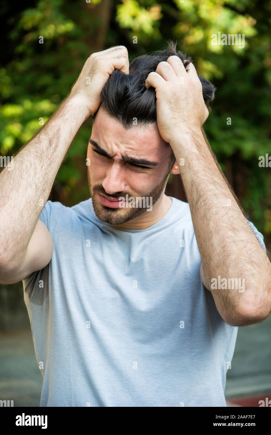 Confused young man scratching his head, looking down Stock Photo - Alamy Confused young man scratching his head, looking down Stock Photo - Alamy