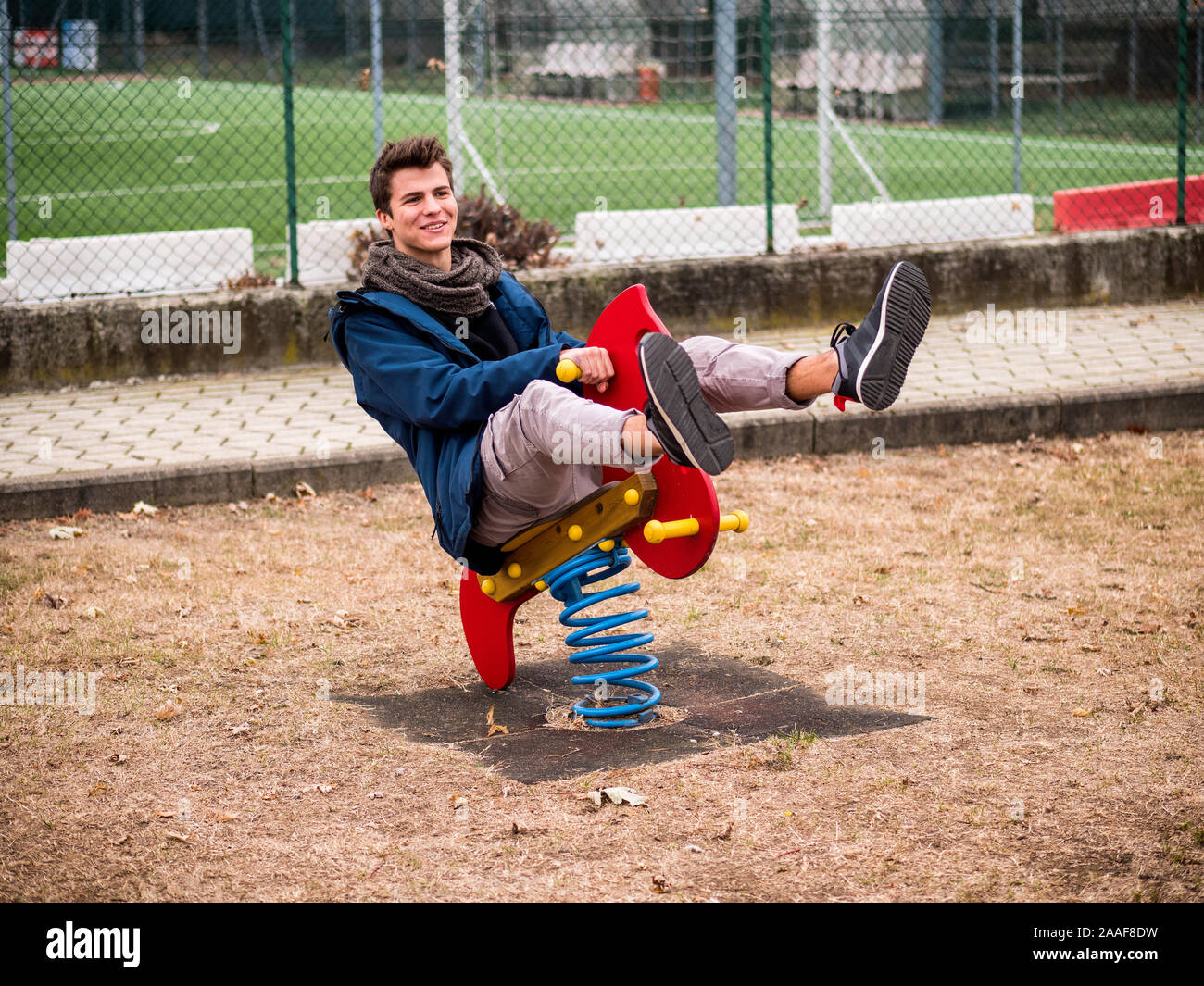 Young man reliving his childhood in a playground Stock Photo - Alamy