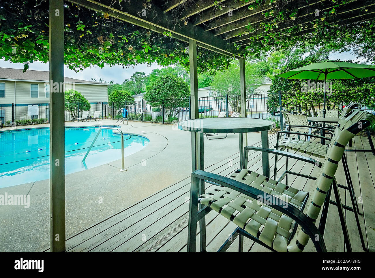 The swimming pool features an outdoor seating area with a covered ...