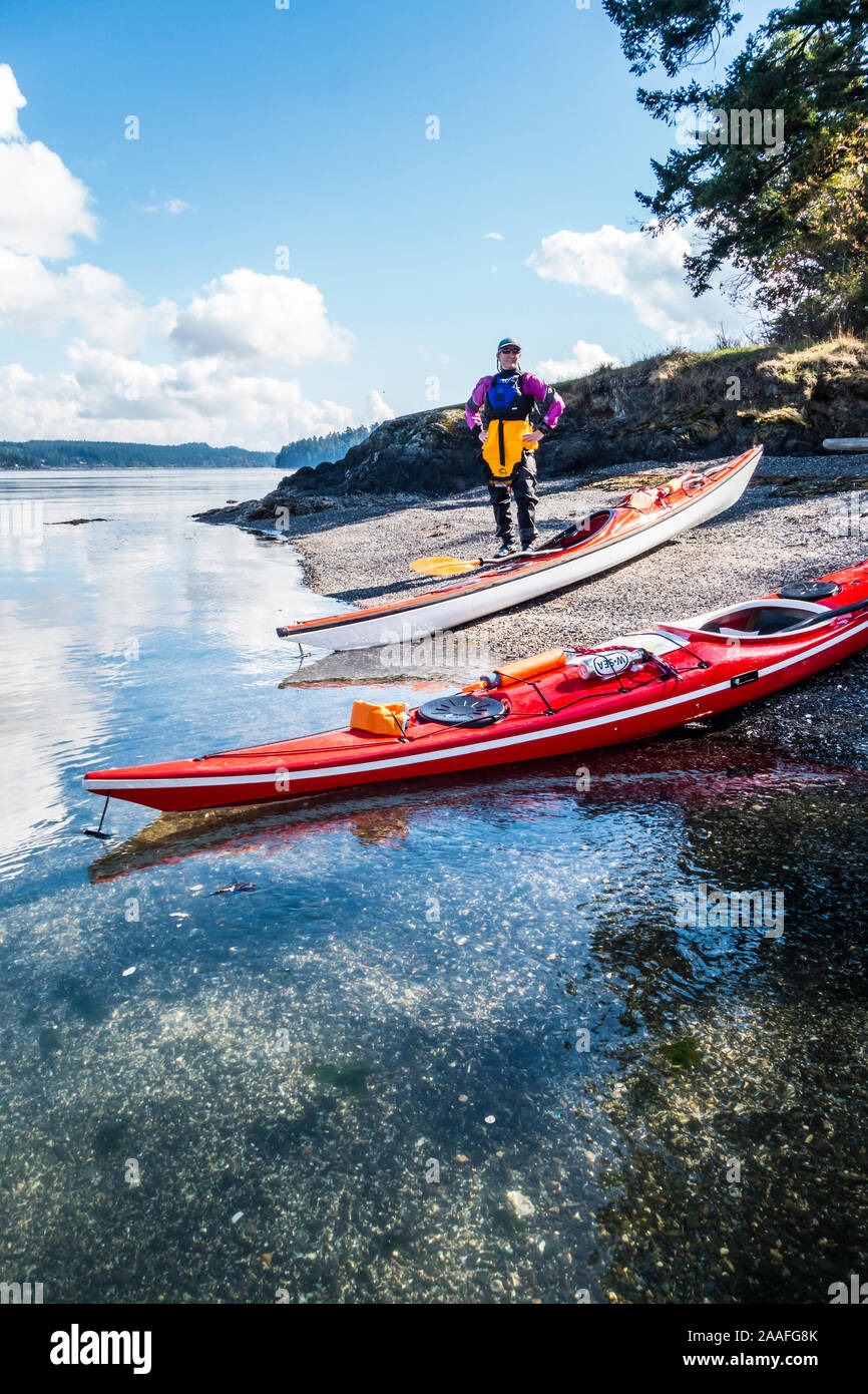 A woman poses for a picture with her sea kayak on Skagit Island ...