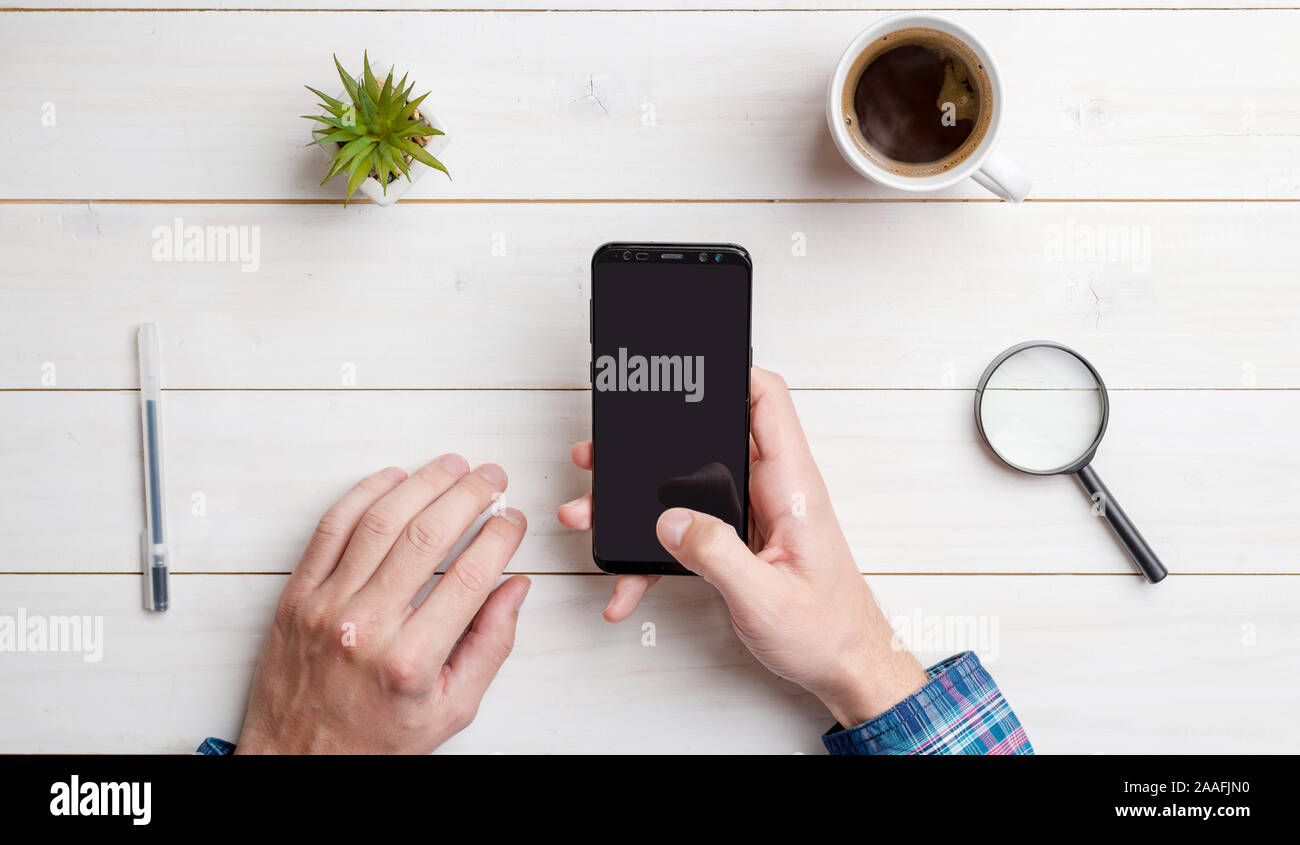 Man hold smart phone with blank screen for mockup. Top views, flat lay ...