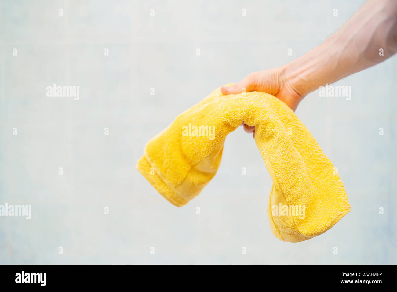 person hand holding a color towel before taking a bath Stock Photo - Alamy