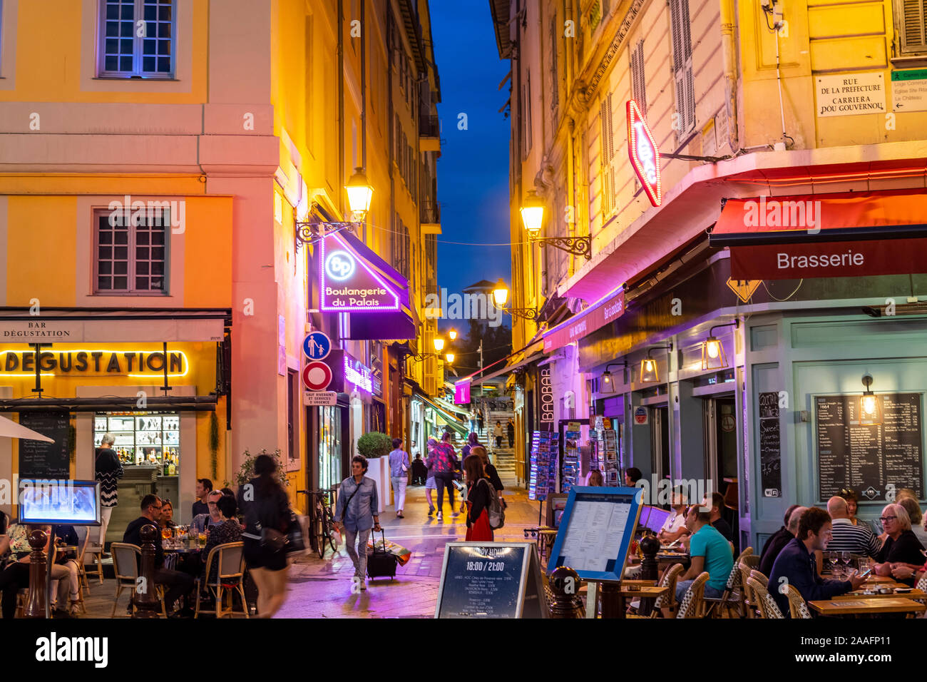 Colorful night view of tourists and local French enjoying sidewalk ...