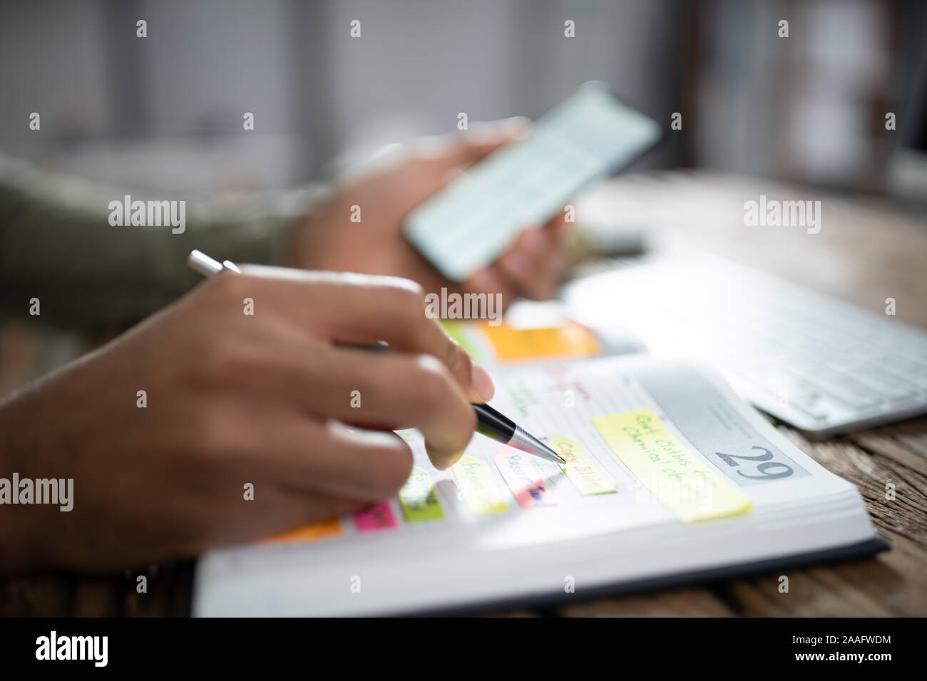 Close-up Of Businessman Writing Schedule In Calendar Diary On Desk ...