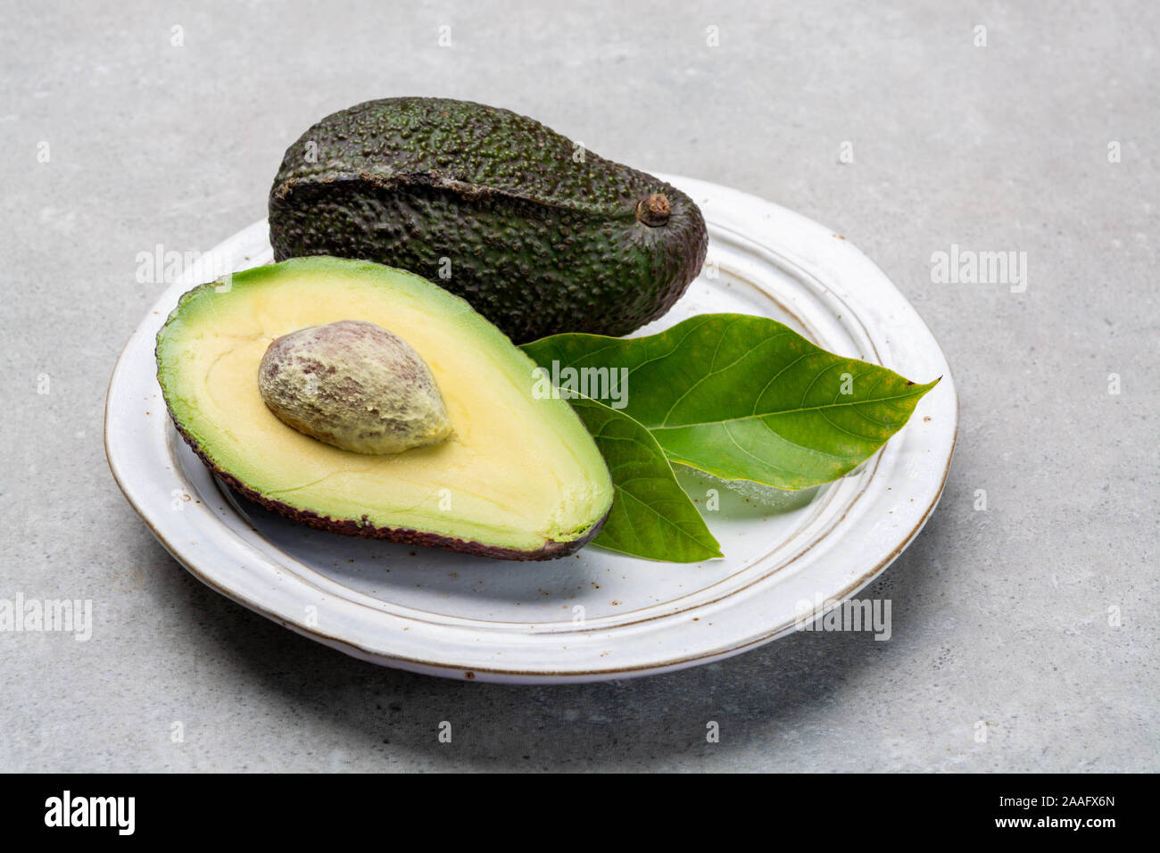 New harvest of fresh ripe hass avocado close cut in half with seed ...