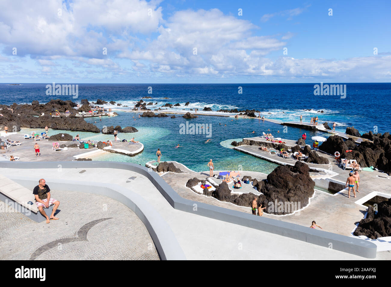PORTO MONIZ, PORTUGAL - AUGUST 2019: Tourists bathing in the natural volcano lava pool in Porto ...