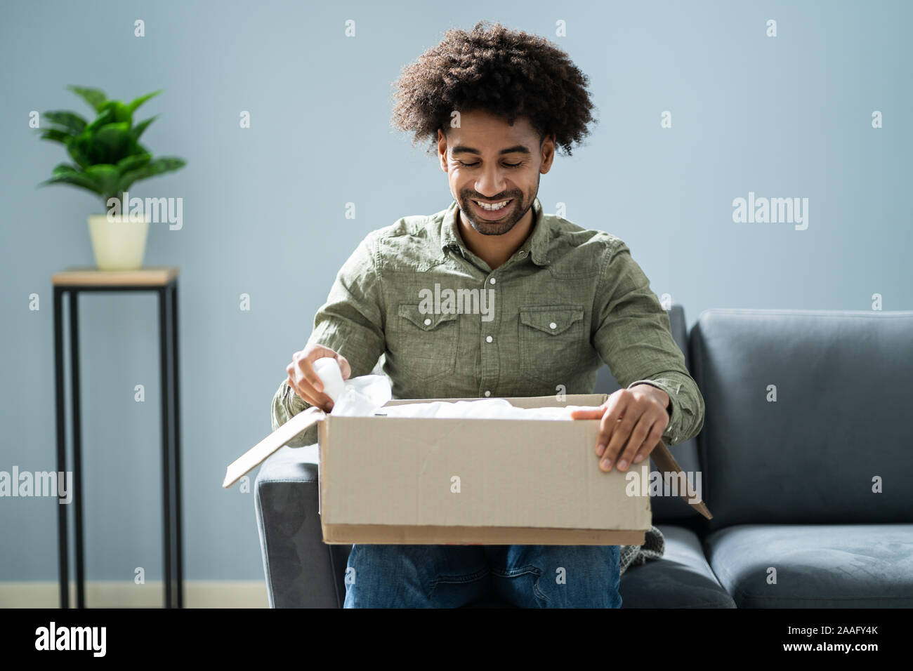 Black man unpacking cardboard box hi-res stock photography and images ...