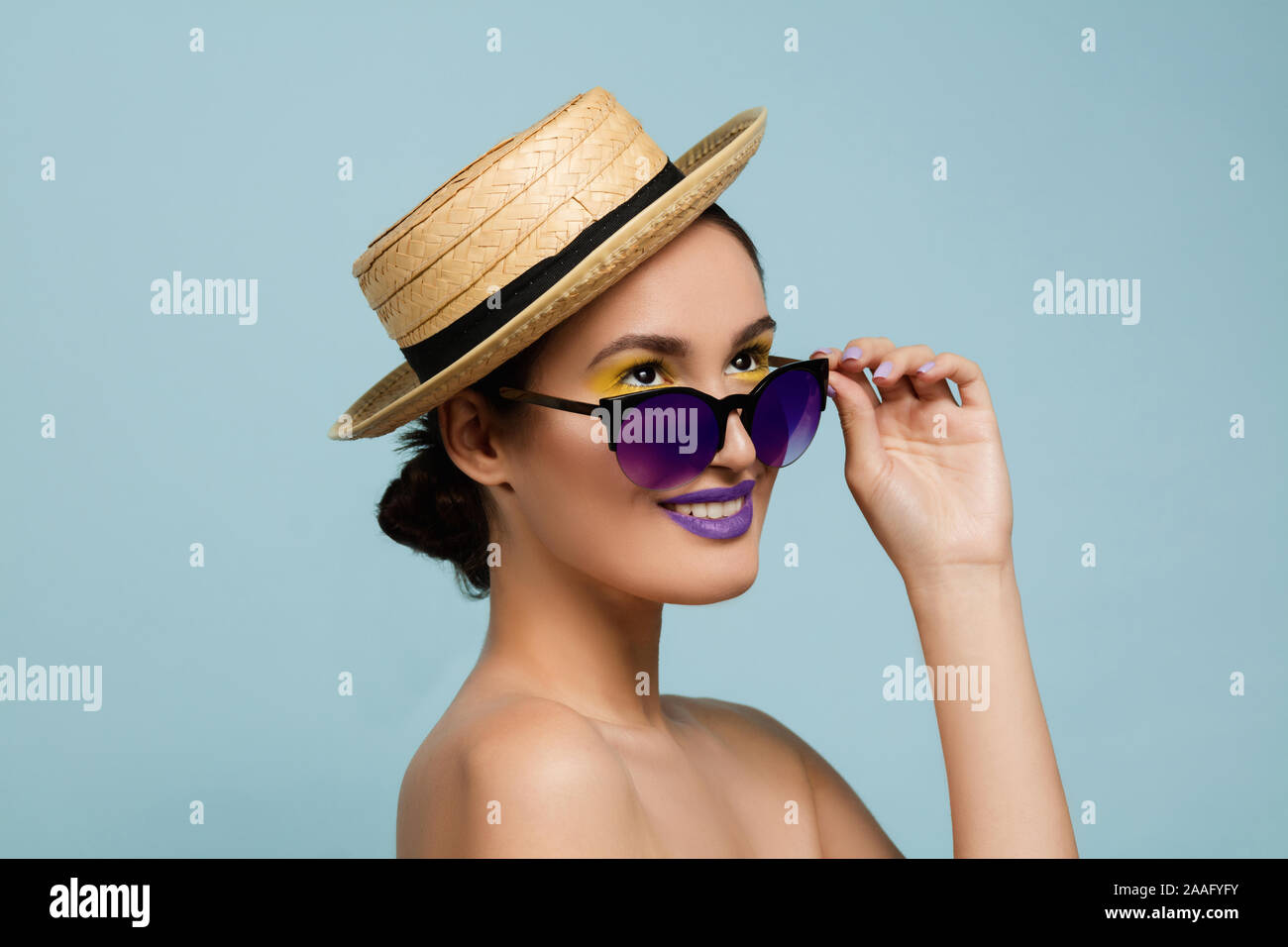 Portrait of beautiful woman with bright make-up, hat and sunglasses on ...