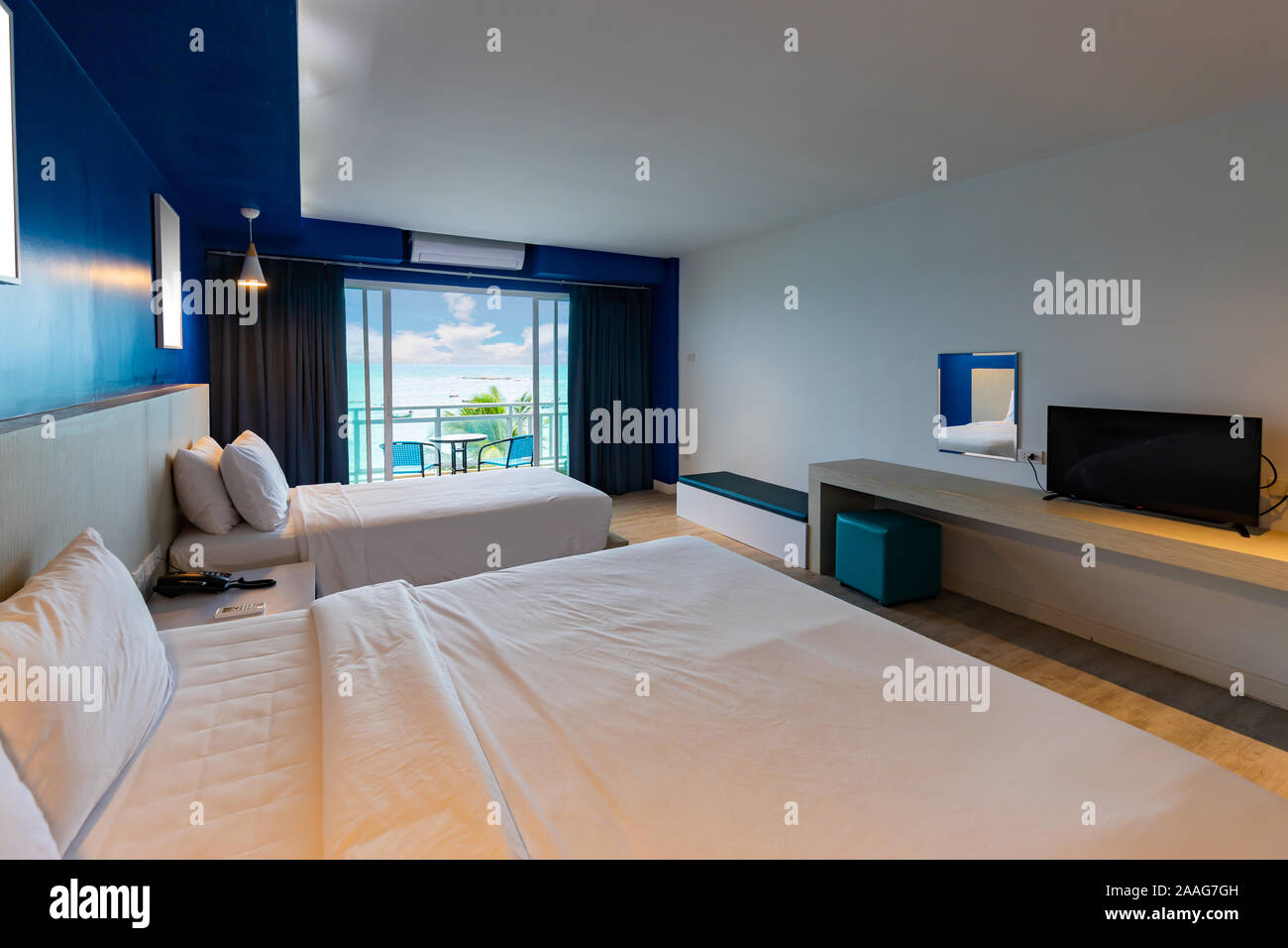 Dark blue tone interior of hotel room with wooden floor with sea view ...