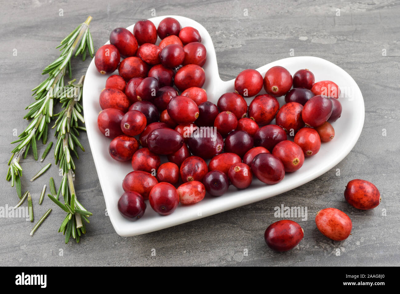 Heart healthy red Cranberries sit merrily on a heart shaped plate ...