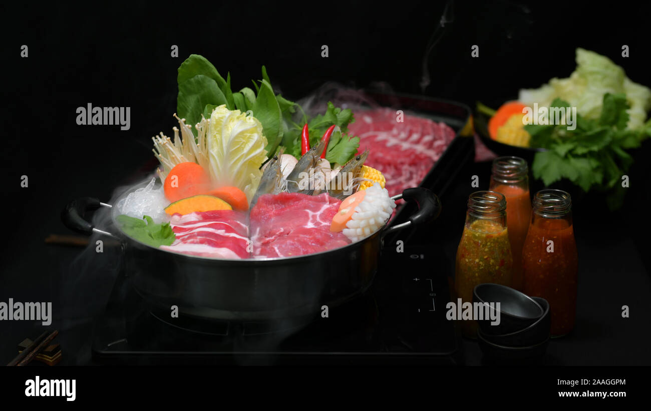 Close-up view of shabu shabu in hot pot with black background, fresh ...