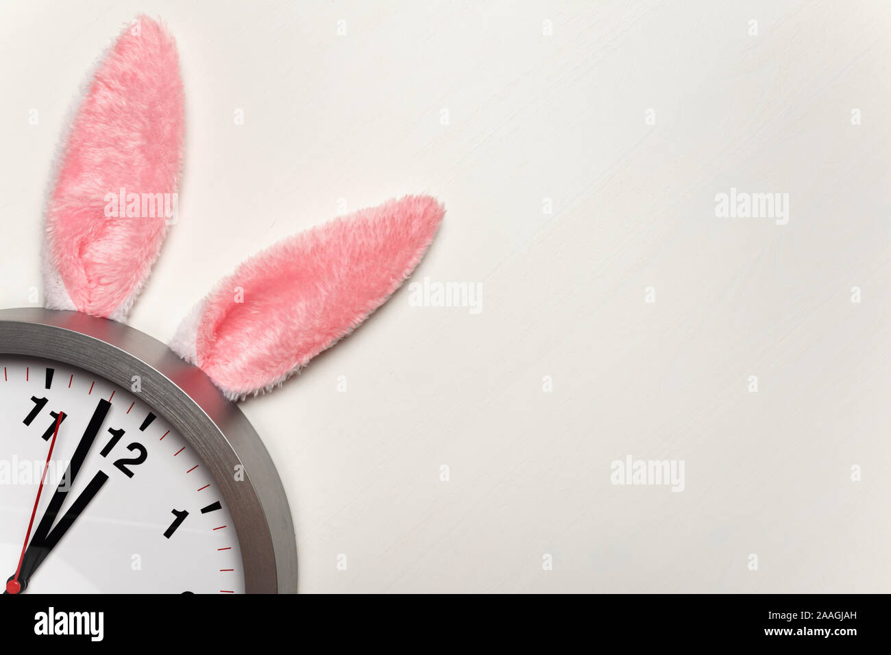 Easter concept. Clock with rabbit ears on a white background. Copy ...