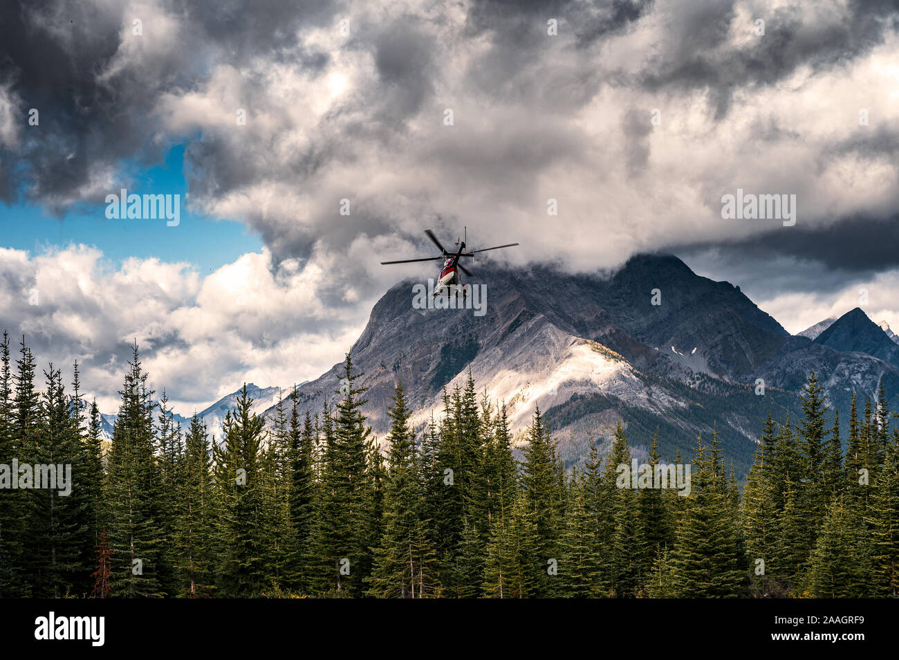 Commercial Helicopter flying with dark sky into the Assiniboine ...