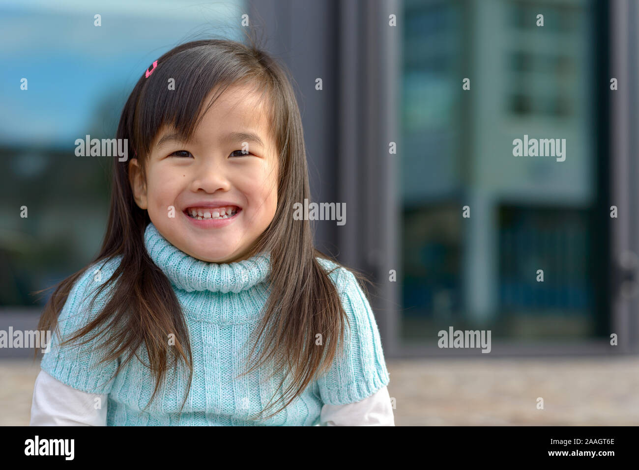Fun happy pretty little girl grinning at the camera as she poses ...