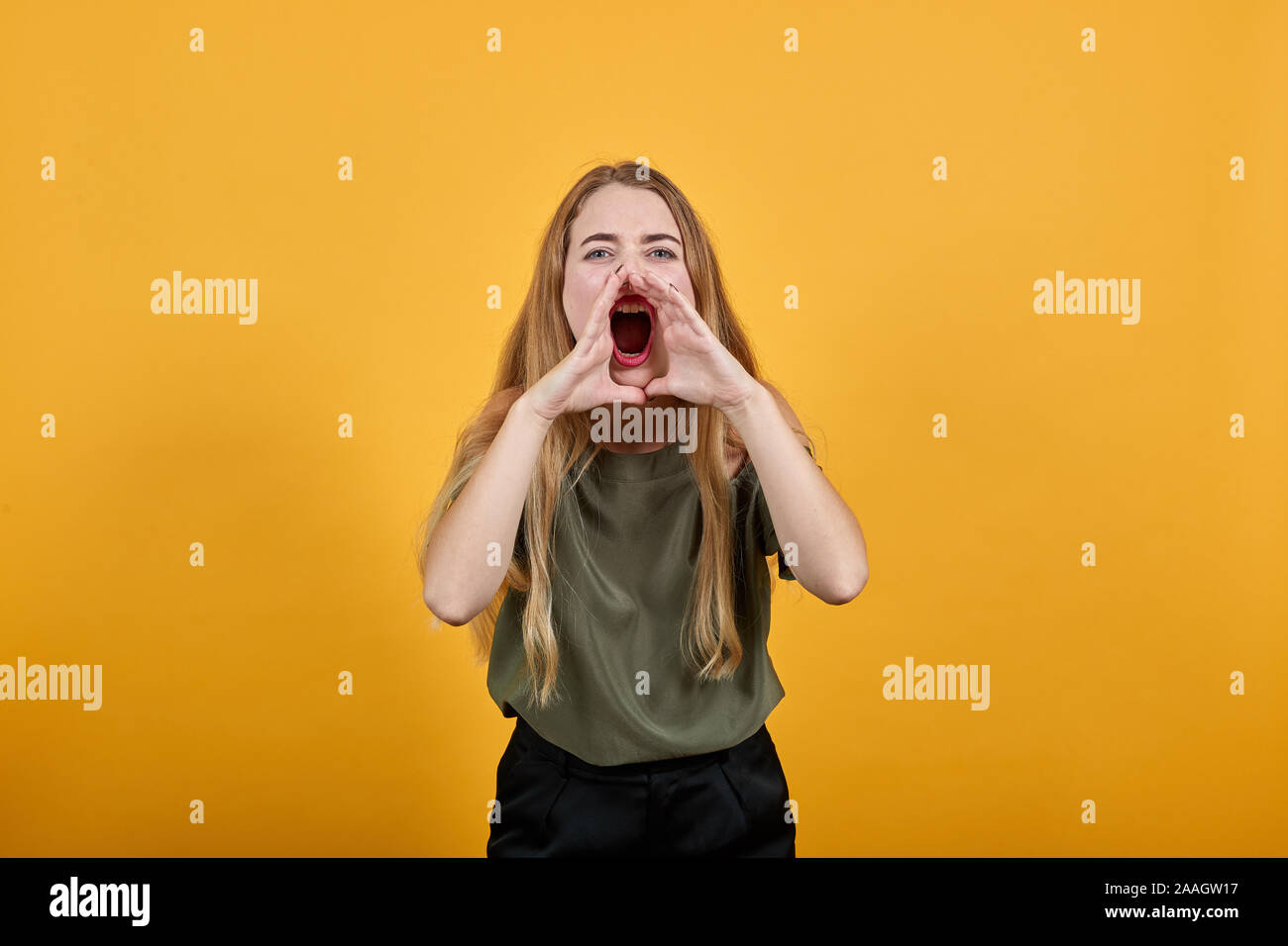 Attractive young caucasian woman shouting and announcing something ...
