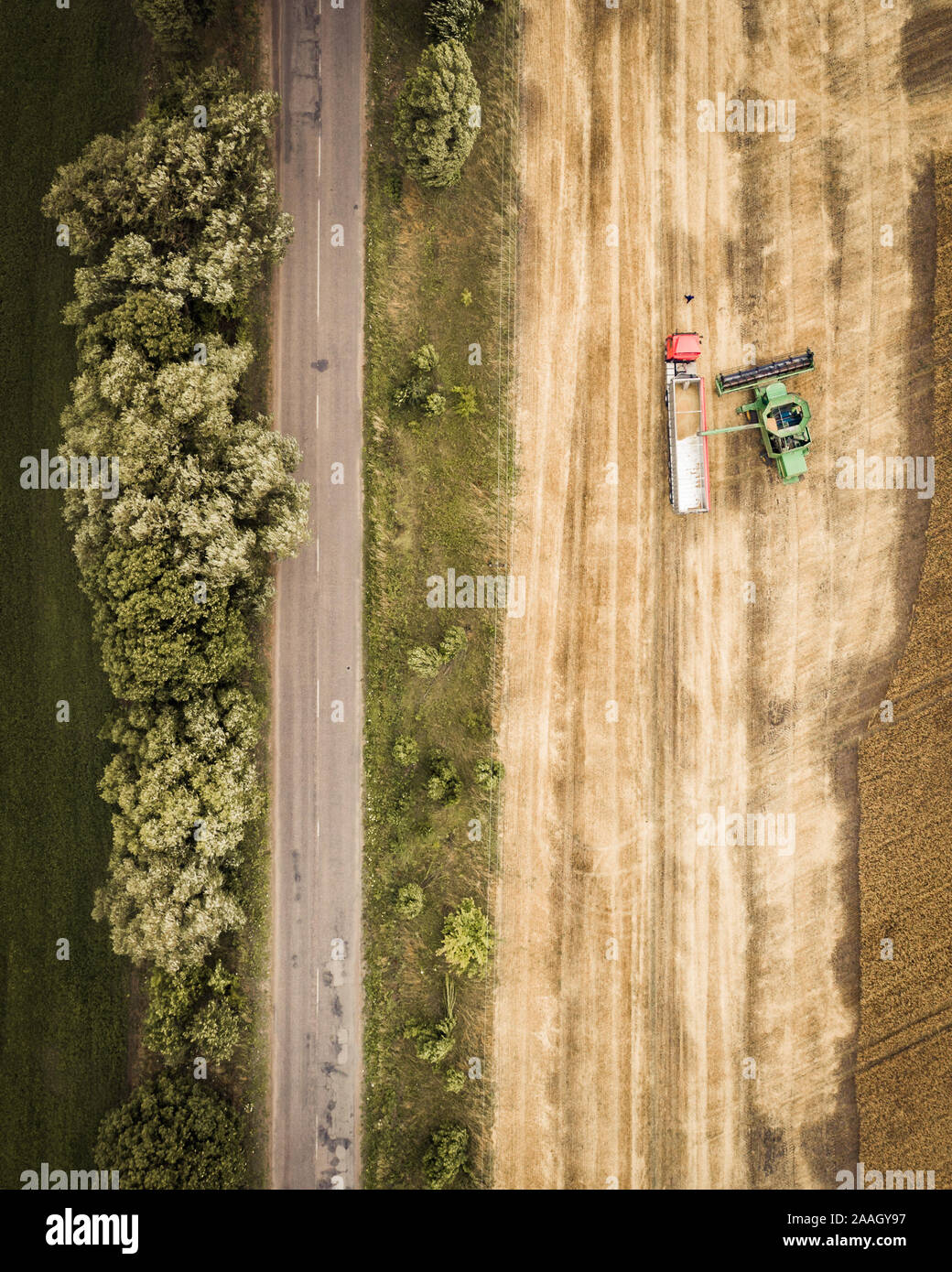 Aerial view of a combine that unloads grain from its grain compartment ...