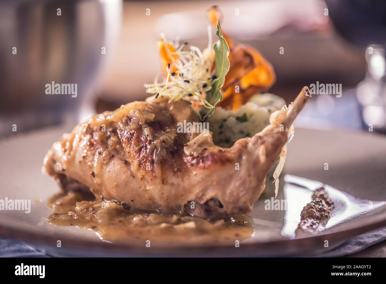 Rabbit leg with mashes potatoes and decoration on plate in restaurant ...